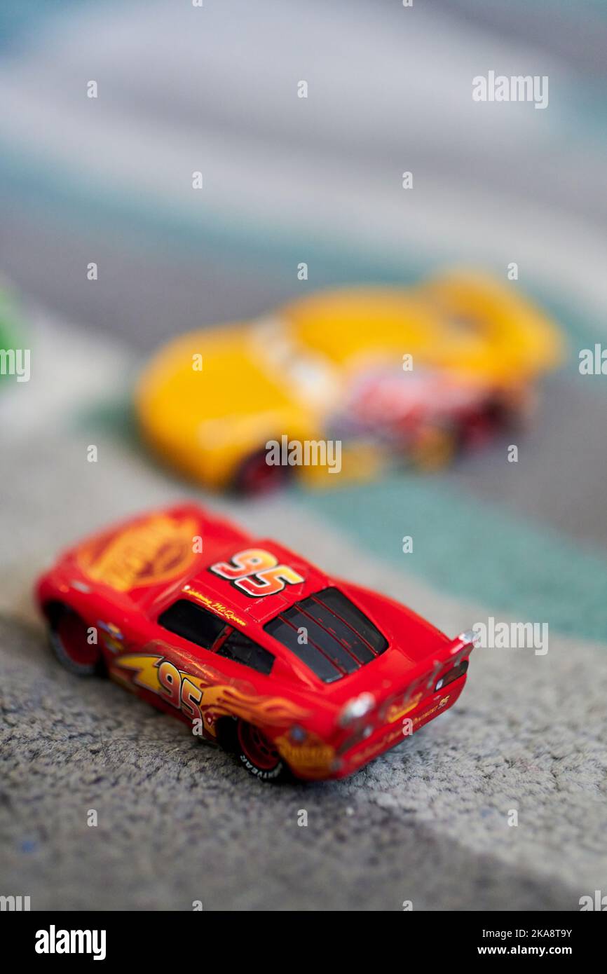 A vertical shallow focus of toy cars on a carpet - Lightning McQueen ...
