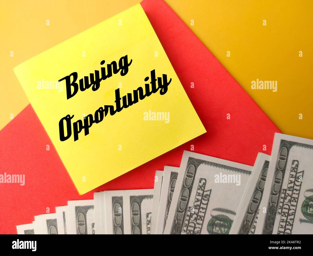 A top view of banknotes and sticky note with the text "Buying ...