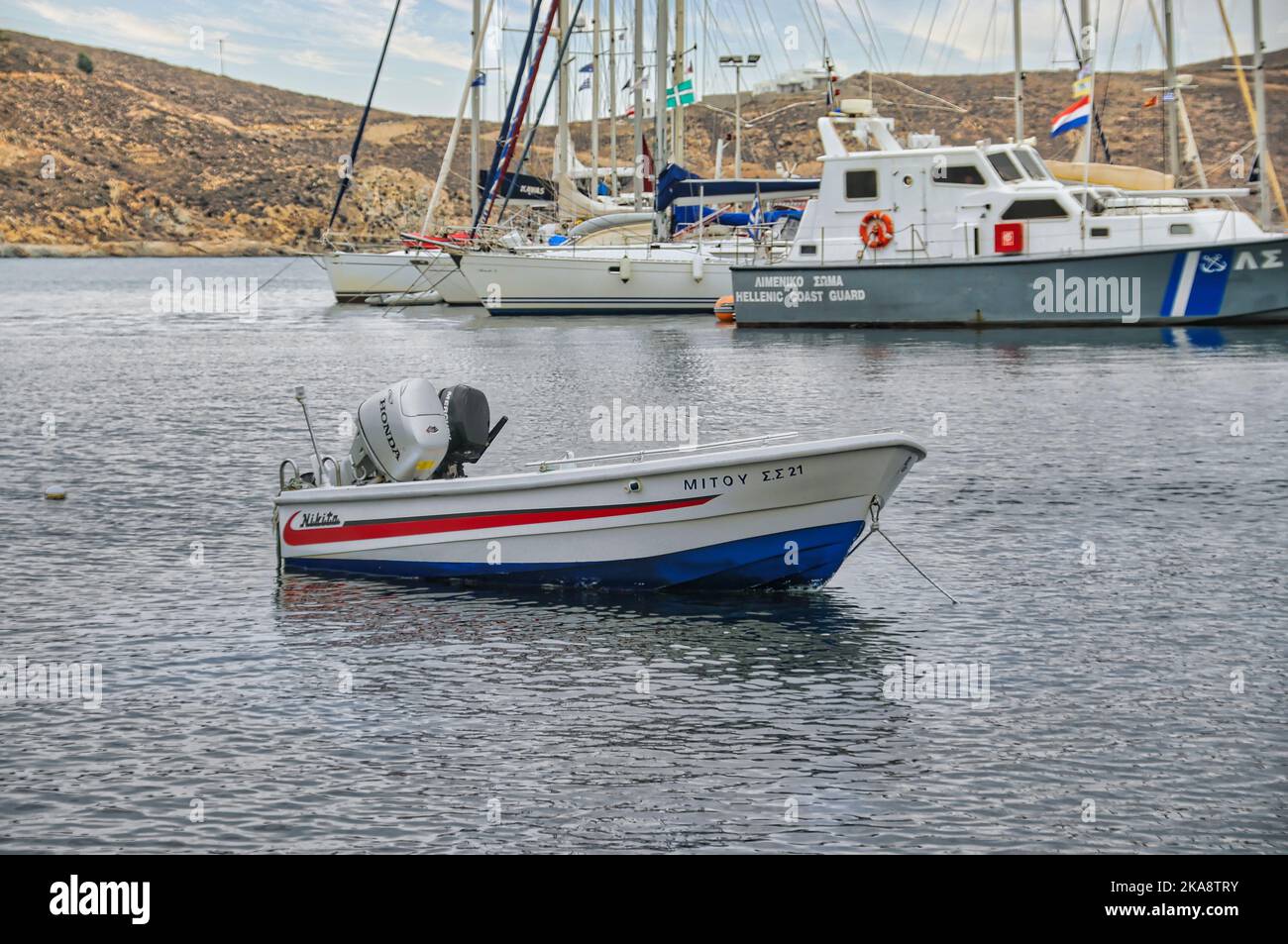 A beautiful small white boat in the water in village Livadi on Serifos ...