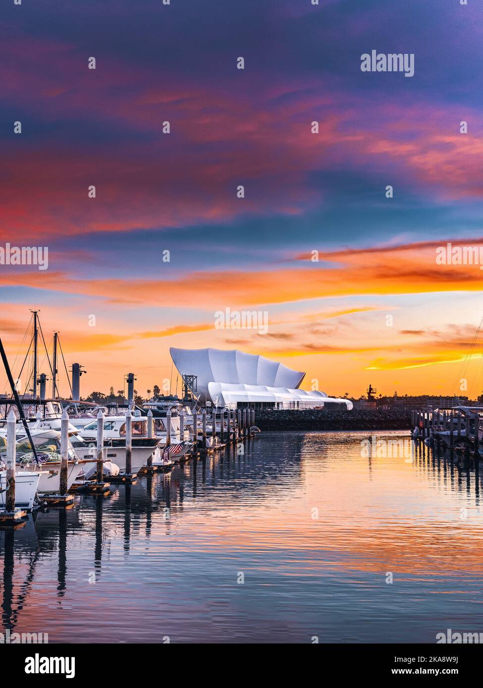 A vertical shot of a bright sunset sky over a seaport village in San ...