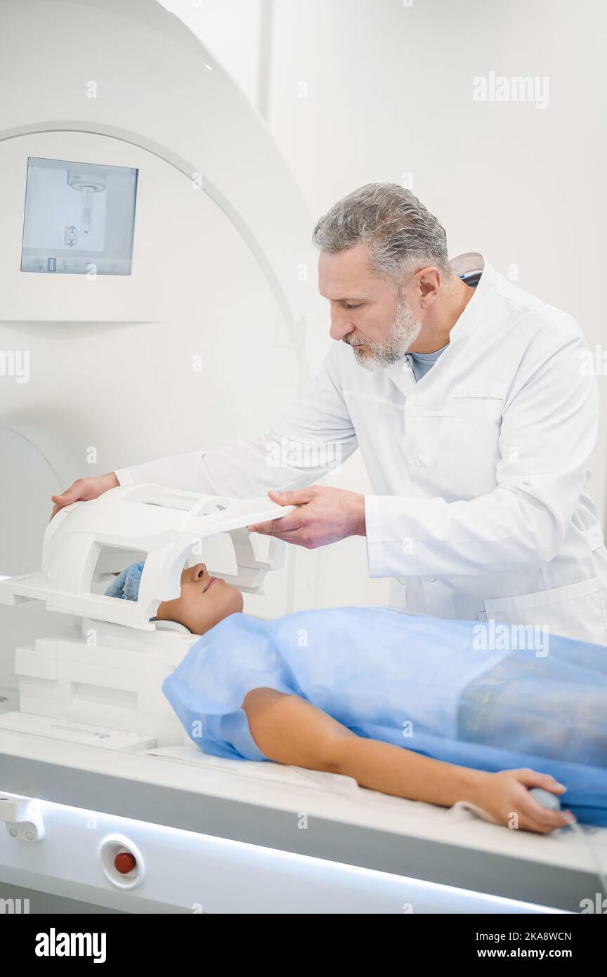 Female patient lying on a couch before MRI scanning Stock Photo - Alamy