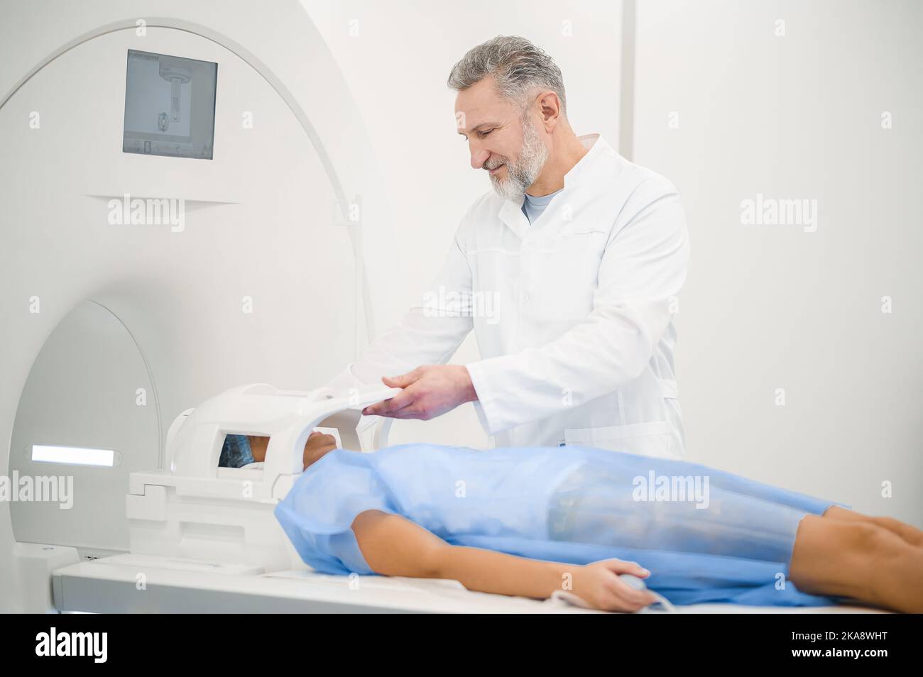 Female patient lying on a couch before MRI scanning Stock Photo - Alamy