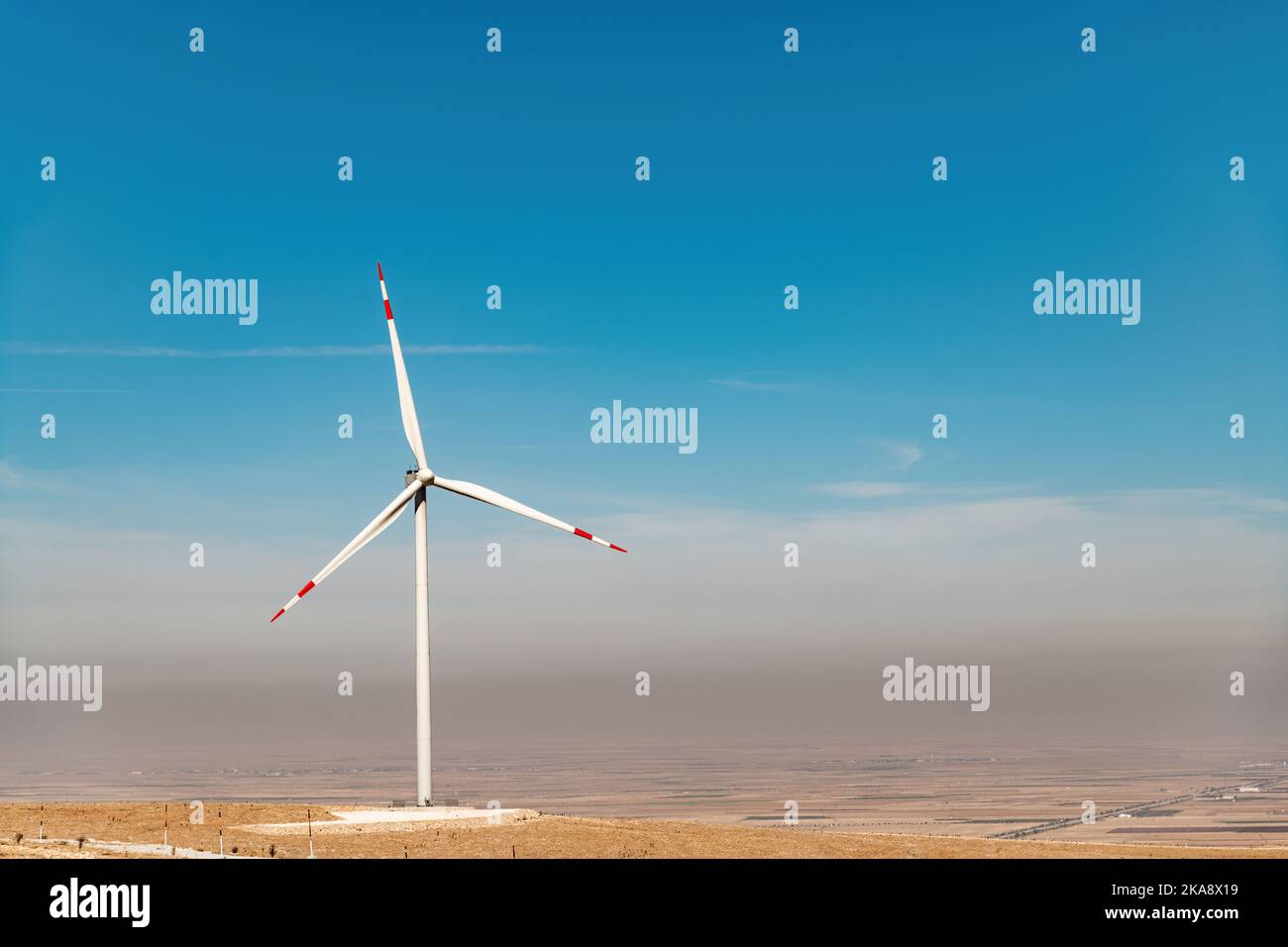 Wind turbine standing on a hill and generating electricity at sunrise ...