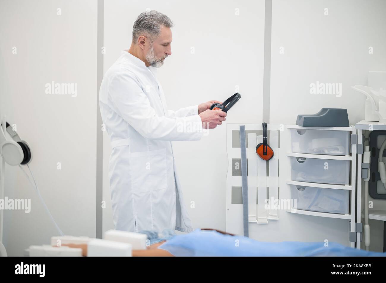 Mature male doctor preparing a patient to MRI investigation Stock Photo ...