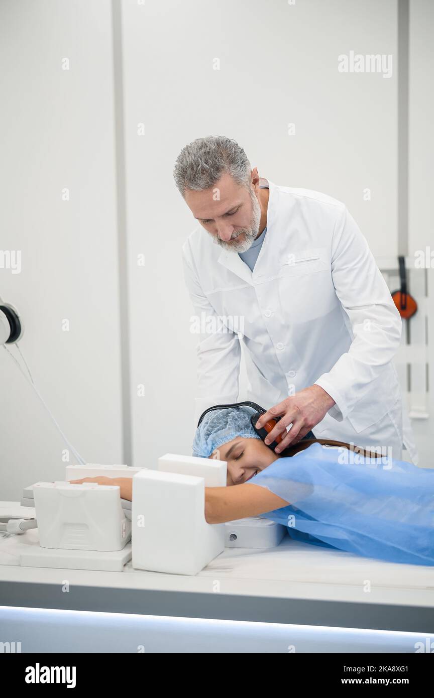 Mature male doctor preparing a patient to MRI investigation Stock Photo ...