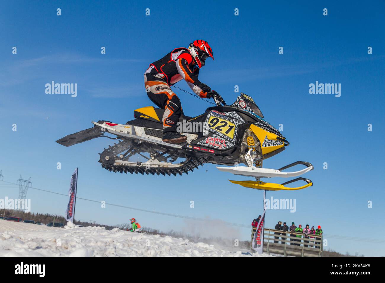 Snowmobiler jumping high above the track. On a snowmobile, a sportsman ...