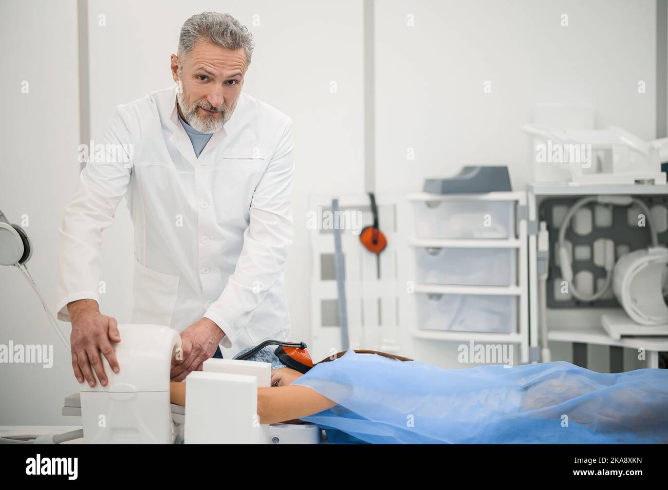 Mature male doctor preparing a patient to MRI investigation Stock Photo ...