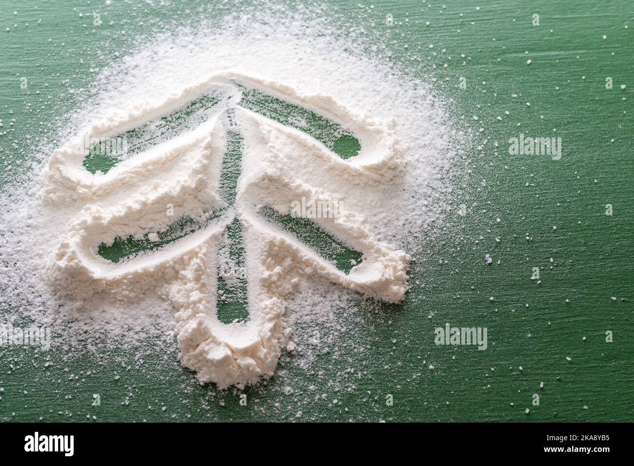 A Christmas tree painted from flour as from snow on a green background ...
