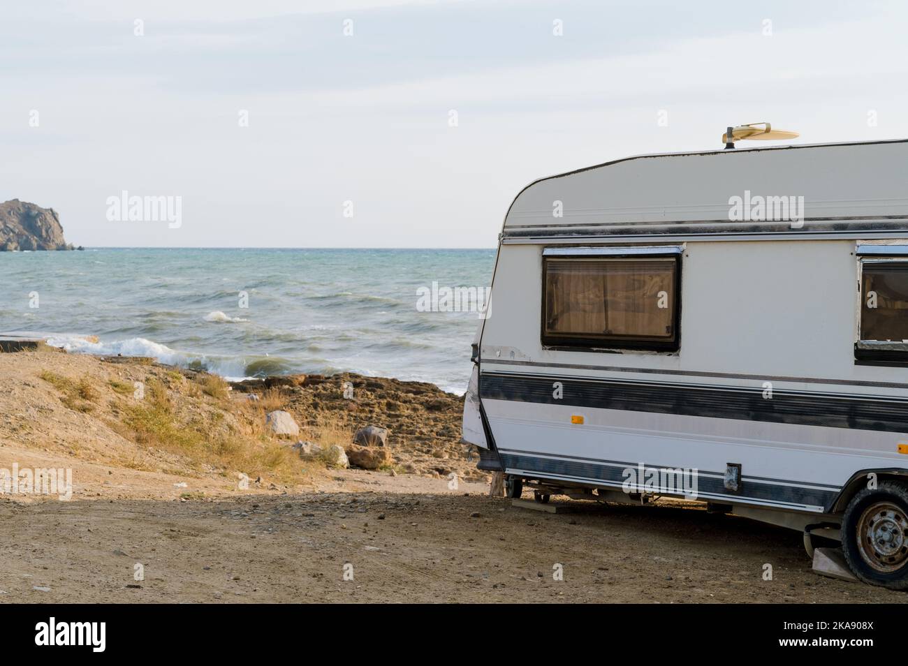 Caravan parked on the seashore. Waves on the water. Scenic camping wild ...