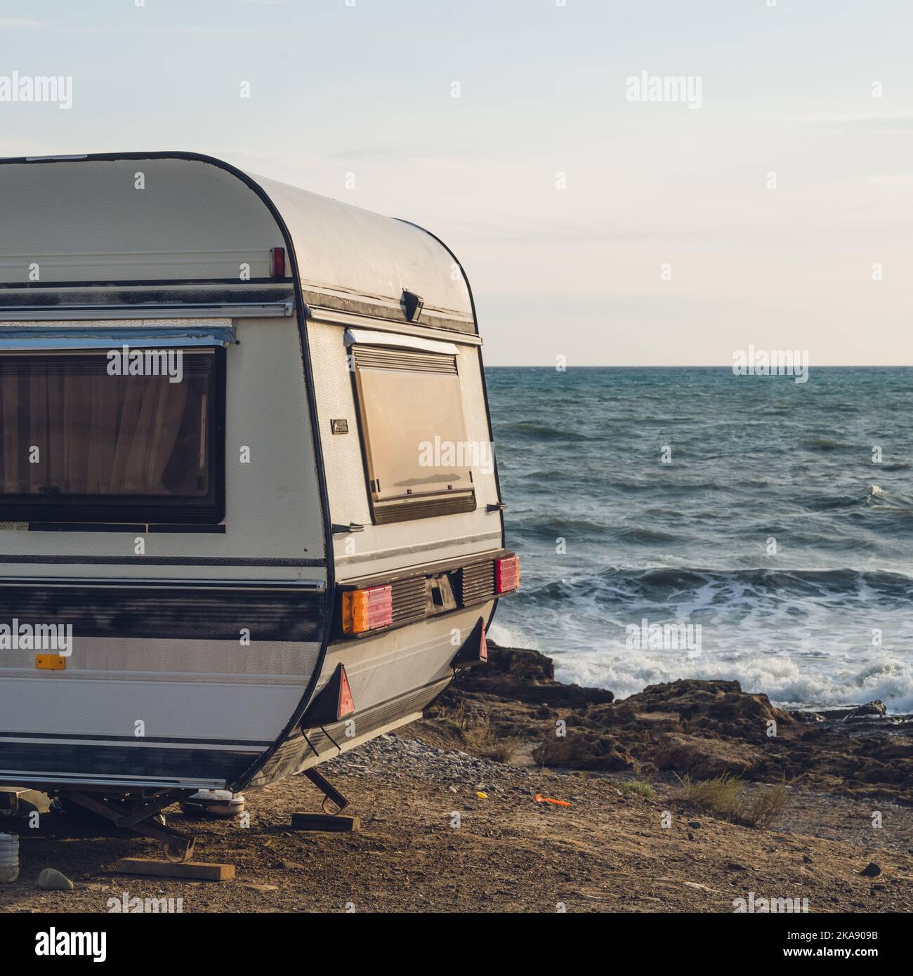 Caravan parked on the seashore. Waves on the water. Scenic camping wild ...