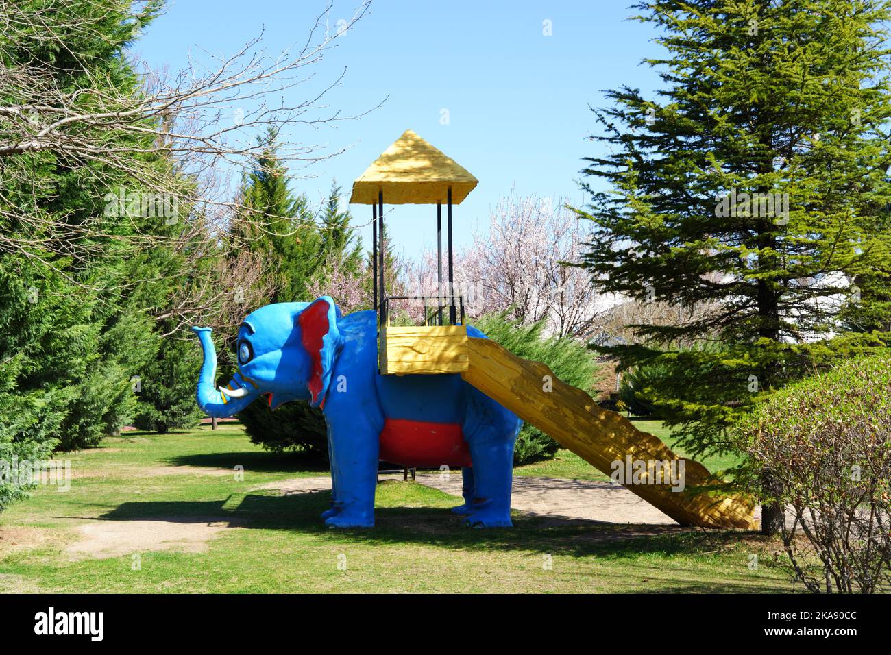 Blue elephant shaped slide within trees on grass in summer Stock Photo ...
