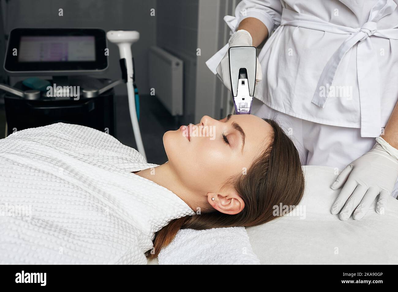 Pretty woman enjoying radiofrequency lifting procedure for her face and ...
