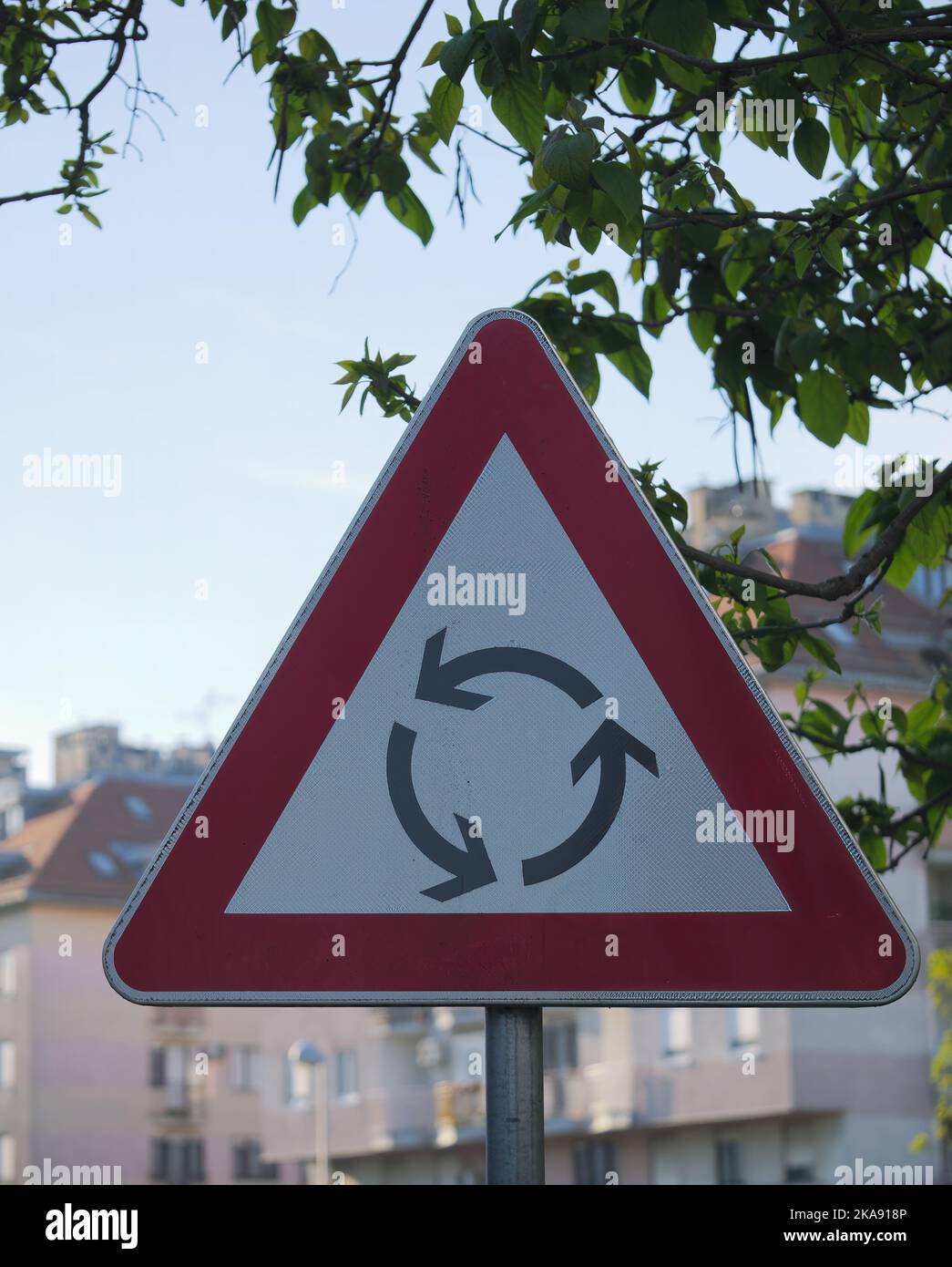 A closeup of a roundabout yield traffic sign attached to a metal pole ...