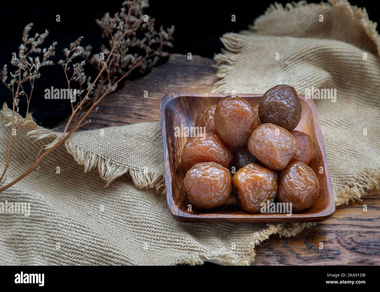 Three flavored preserved chinese plums (Preserved fruits) on wooden ...