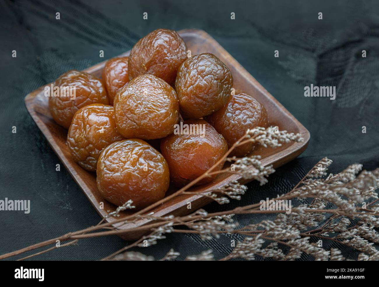 Three flavored preserved chinese plums (Preserved fruits) on wooden ...