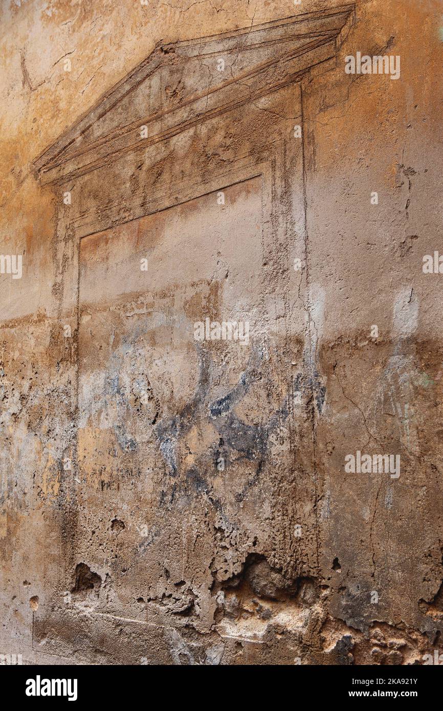 Architectural sketch and remains of graffiti on a weathered stone wall ...