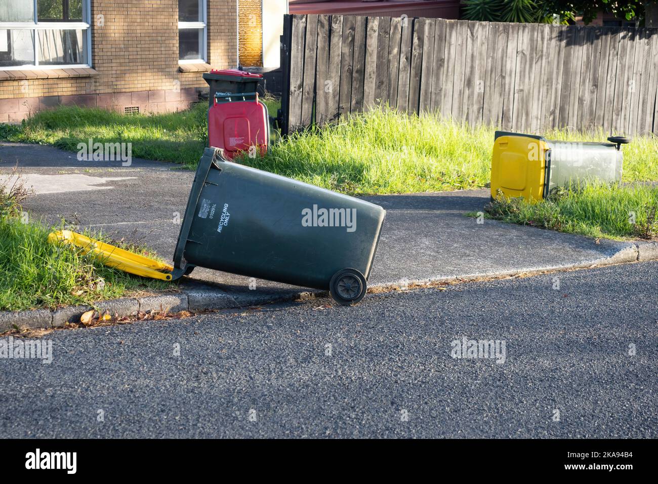 View of rubbish wheelie bins toppled by strong wind laying on ground ...