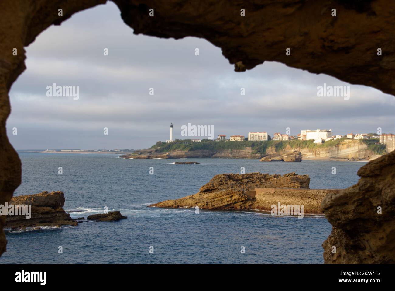 A beautiful view of a lighthouse on a seashore from a cave Stock Photo ...