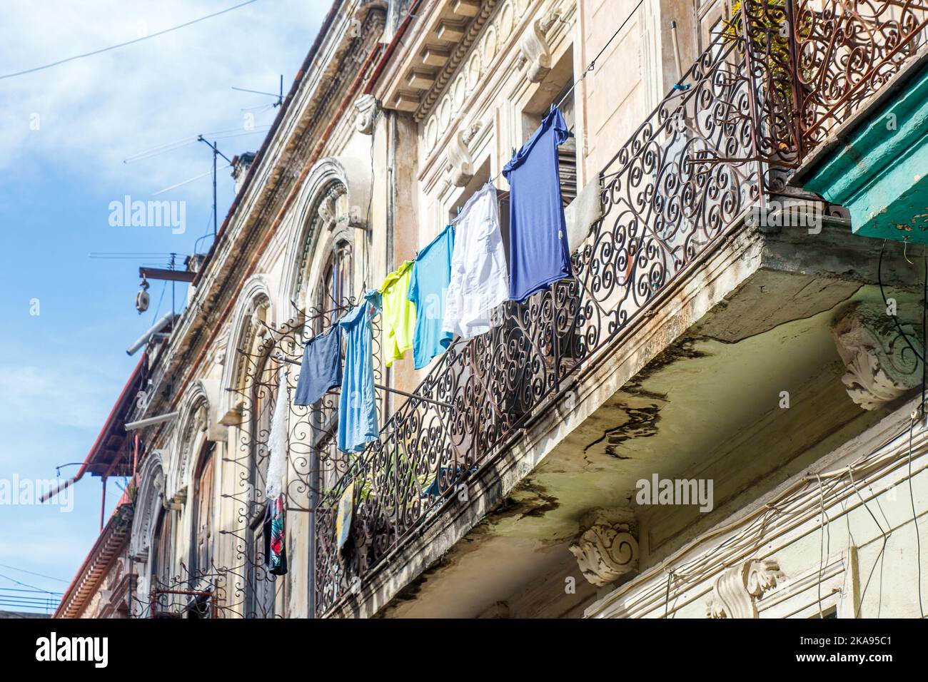 A clothesline with drying clothes hangs from a balcony in a weathered ...