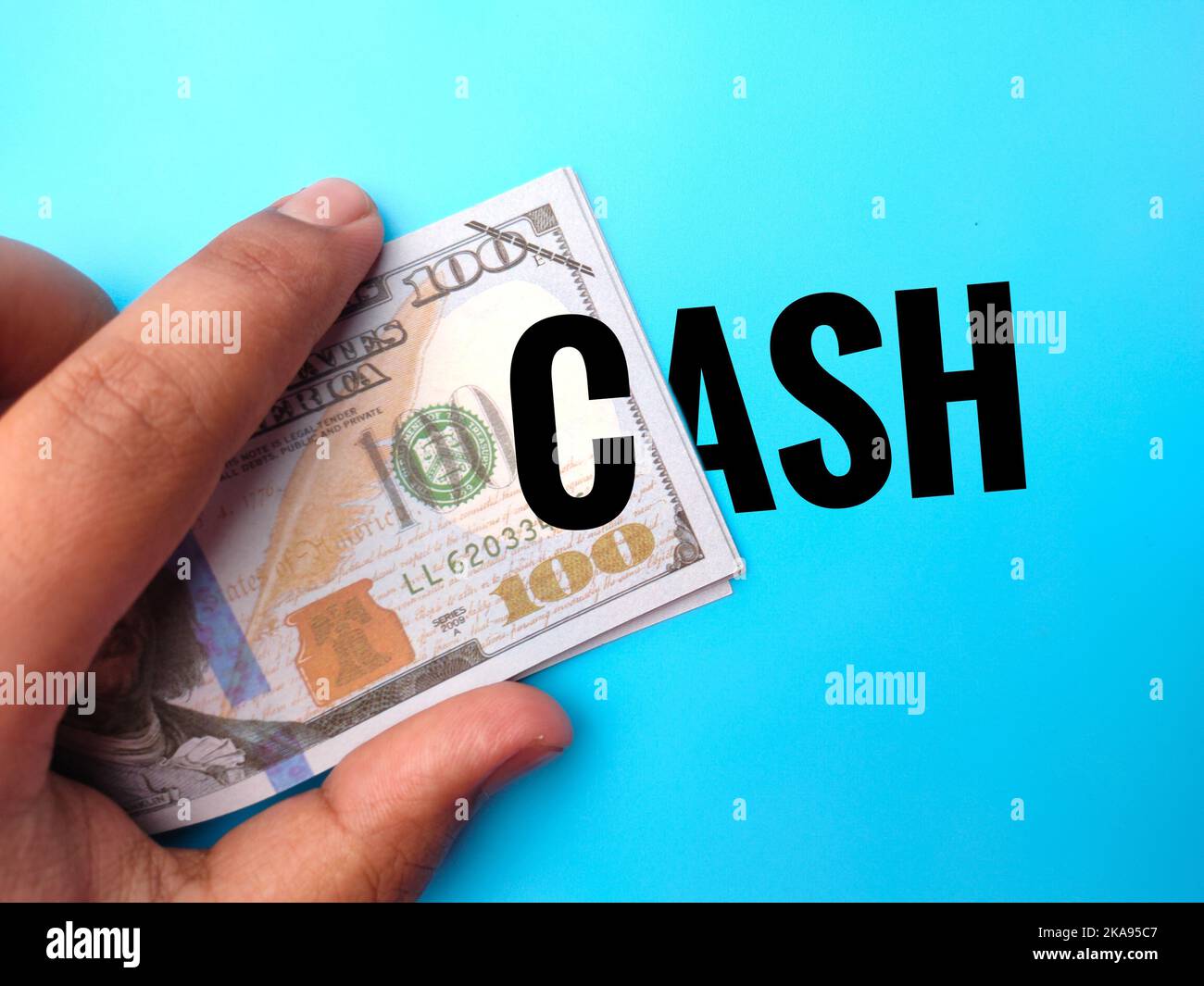 The Hand holding banknotes with the word "CASH" on blue background ...