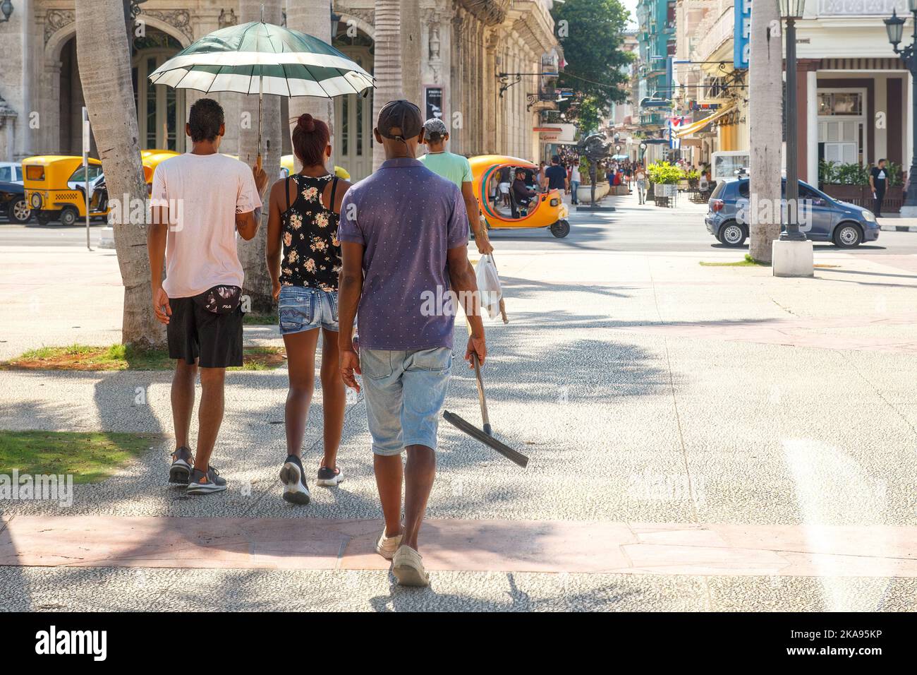 Three Afro-Caribbean young people walk in the downtown district. A ...