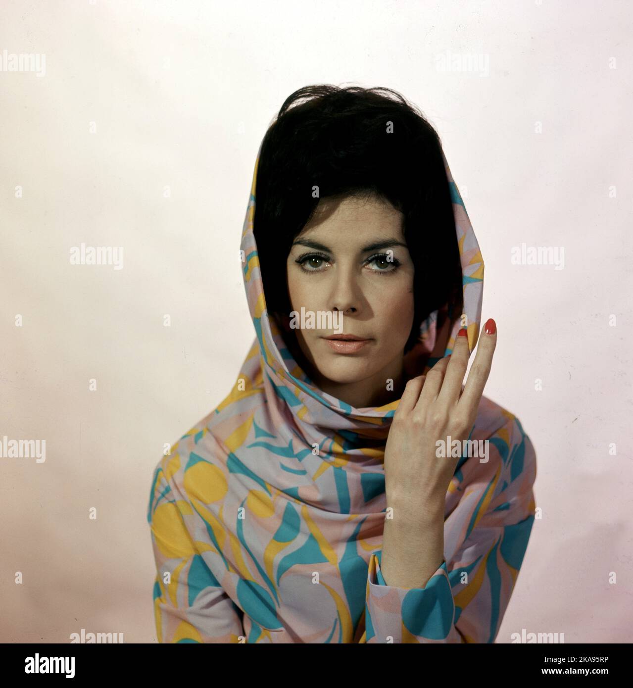 A woman in a hooded top looking into camera with sad expression c1969 ...