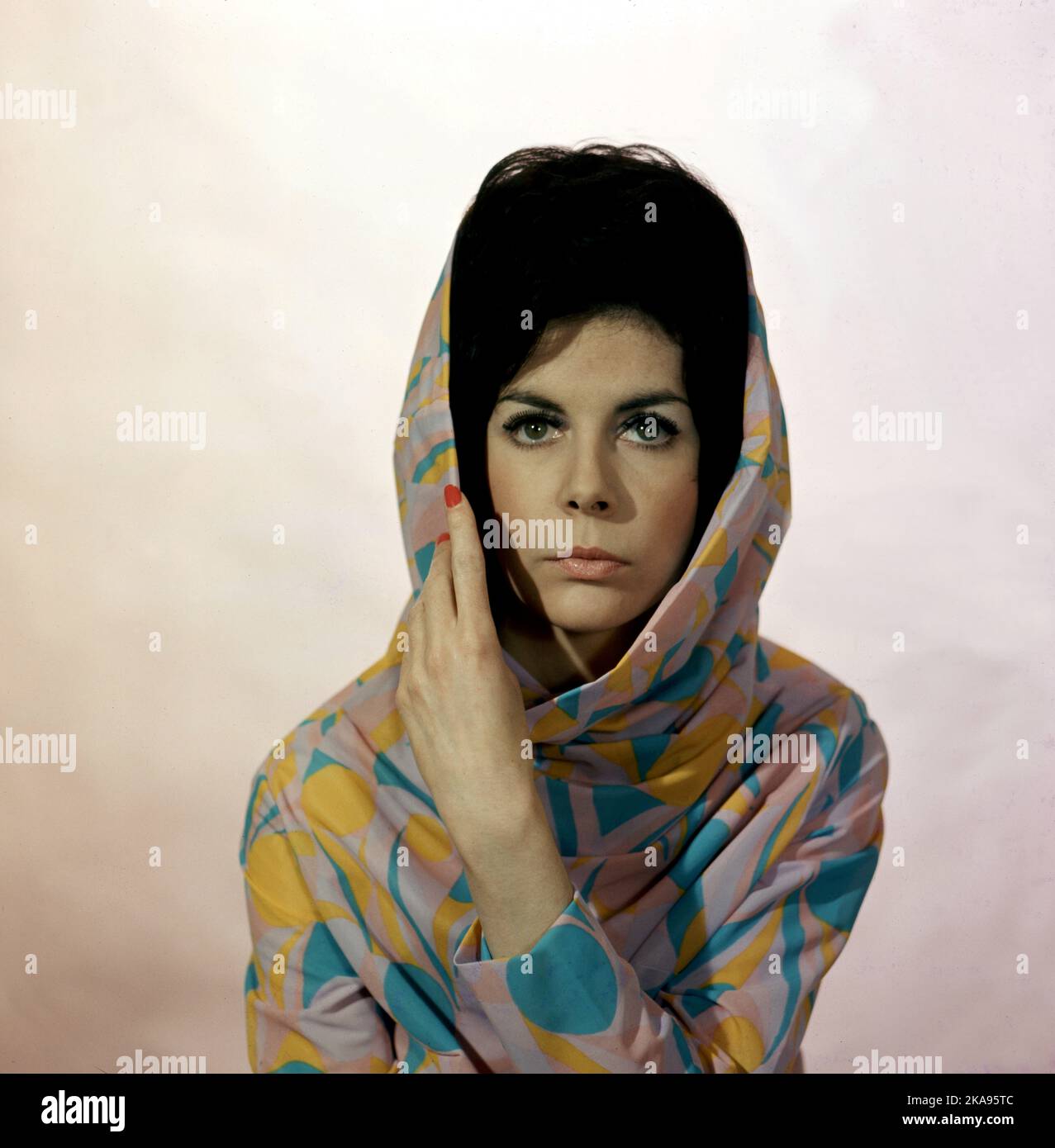 A woman in a hooded top looking into camera with sad expression c1969 ...