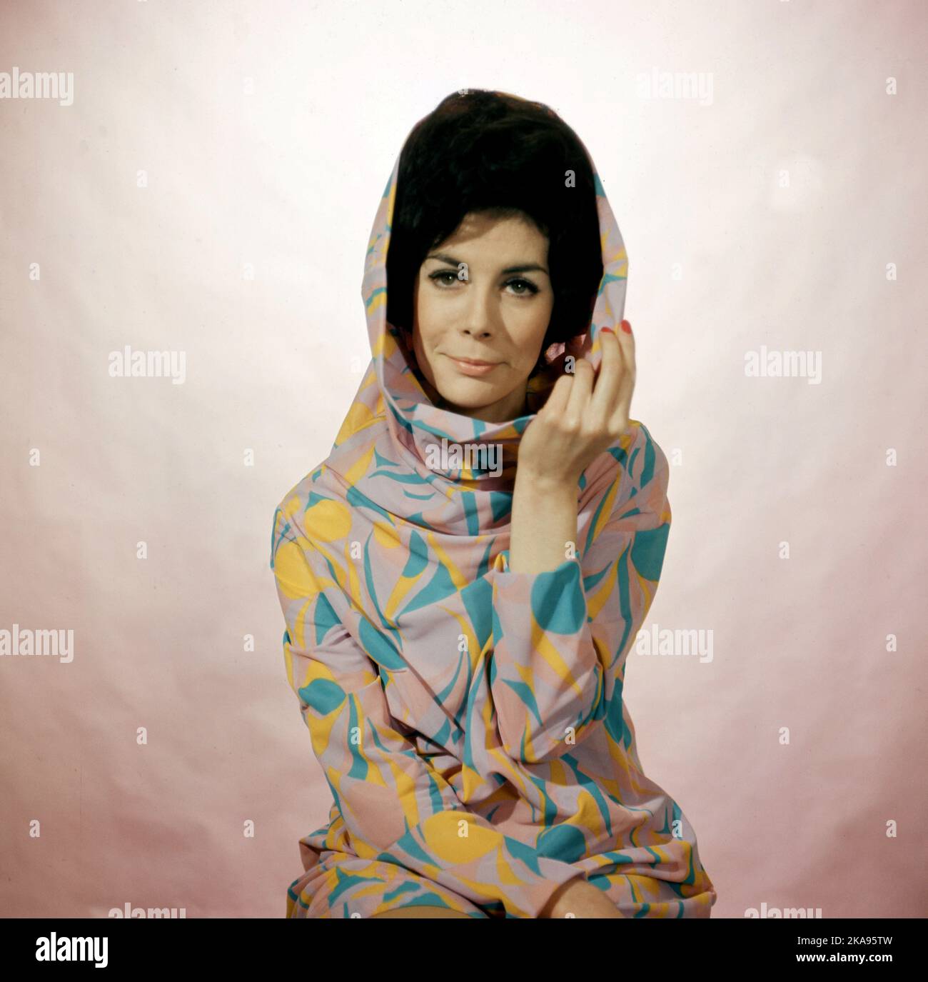 A woman in a hooded top looking into camera with sad expression c1969 ...