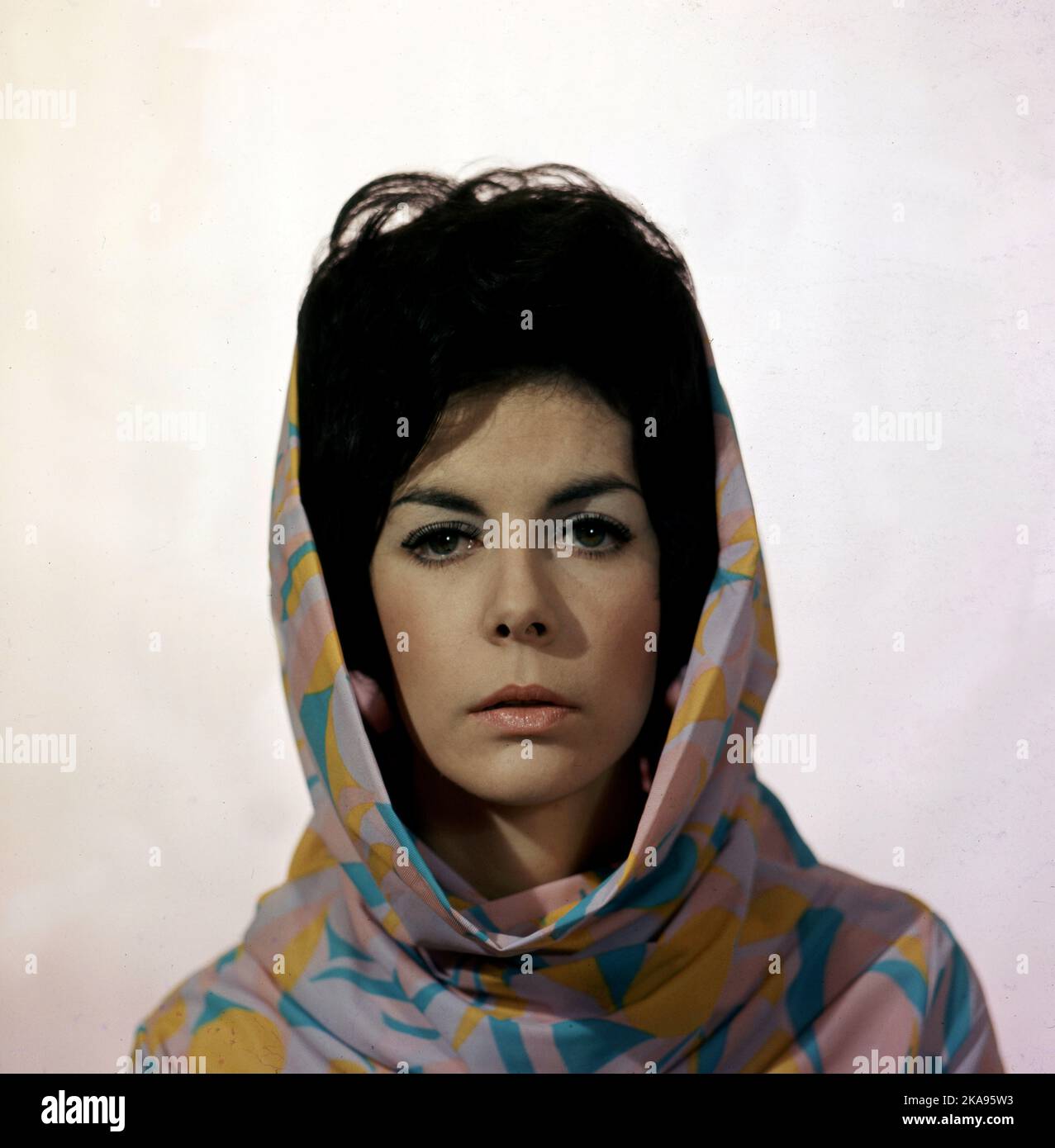 A woman in a hooded top looking into camera with sad expression c1969 ...