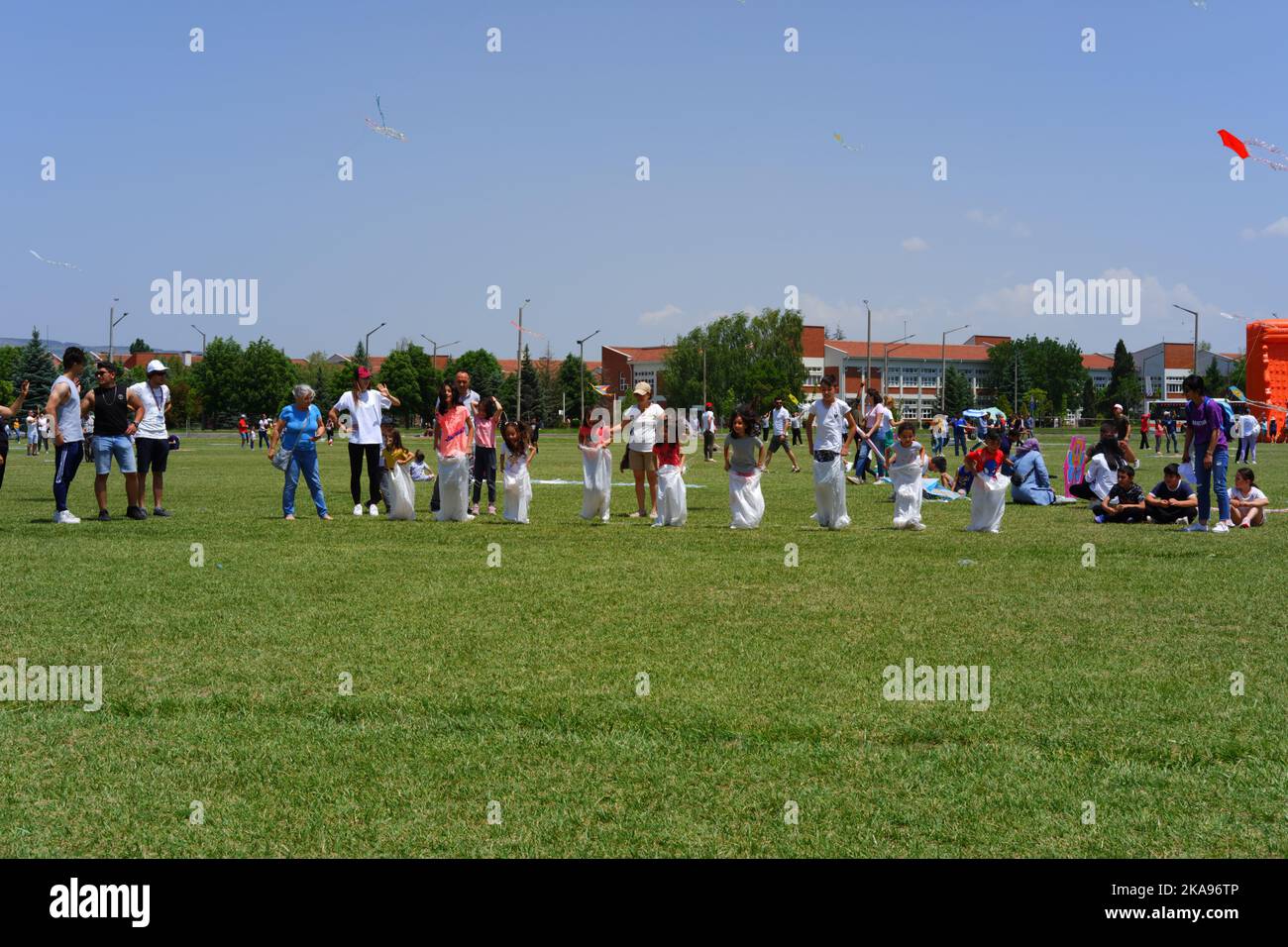 People having fun at gunnysack race on grass in a sunny day. Laughing ...