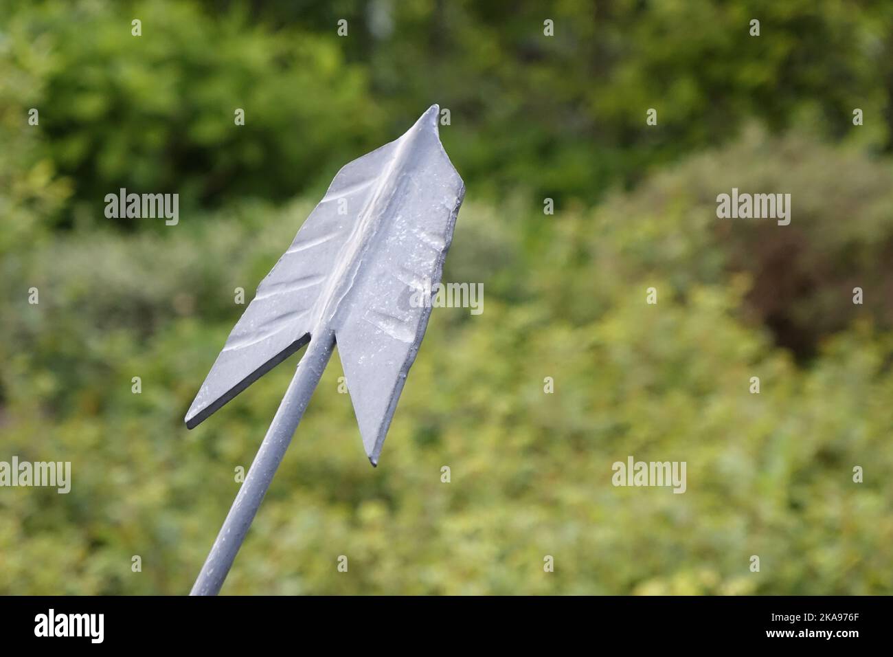 Metal arrow tip pointing right in spring, concept: target, focus, task ...