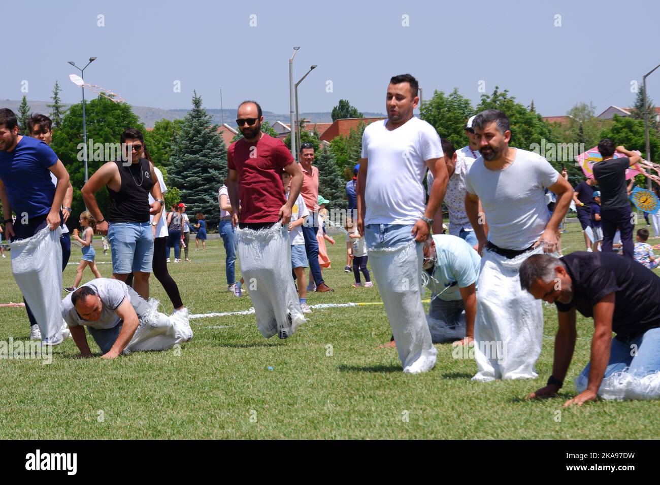 People having fun at gunnysack race on grass in a sunny day. Laughing ...