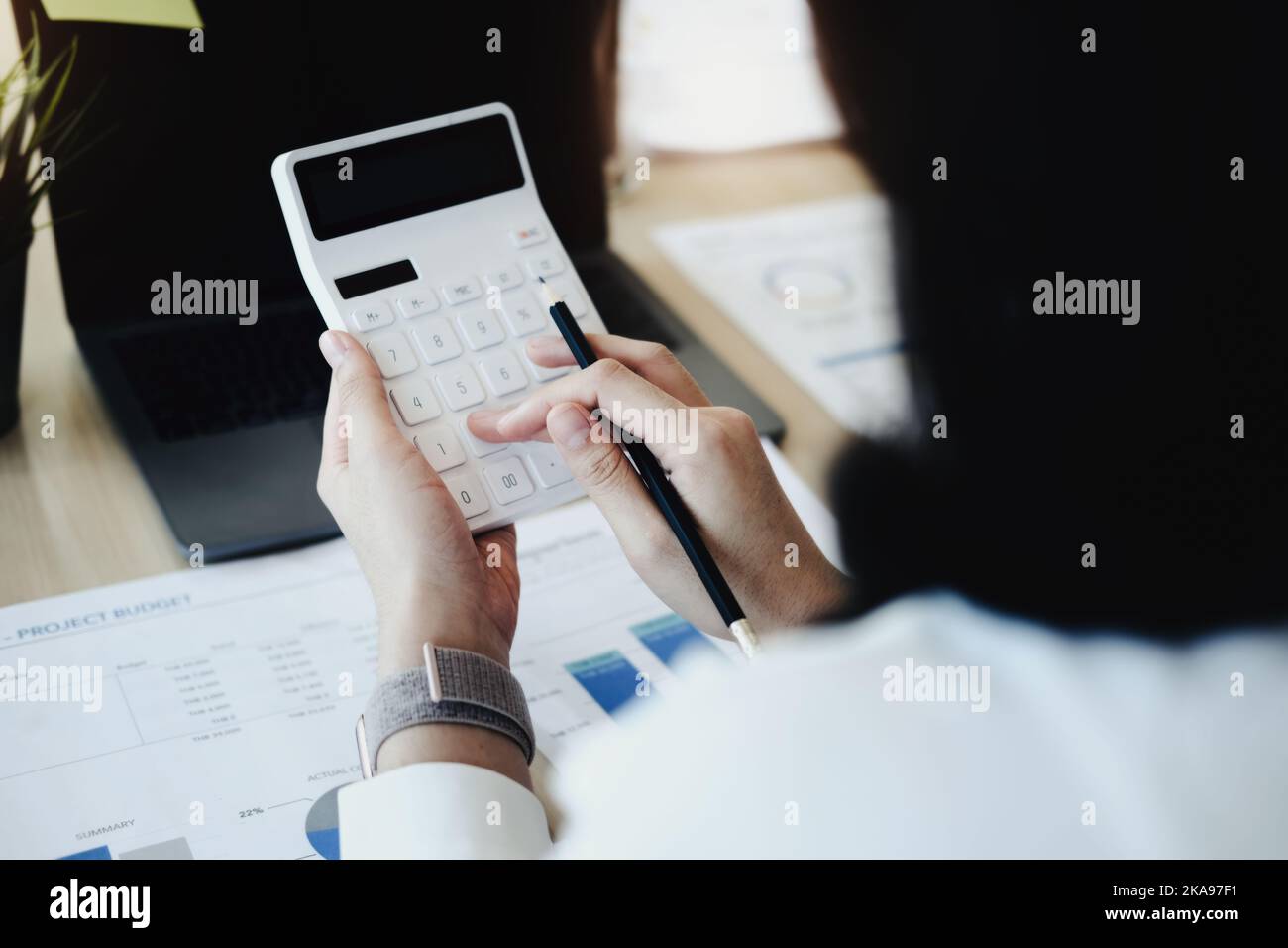 Business woman using calculator to review balance sheet annual using ...