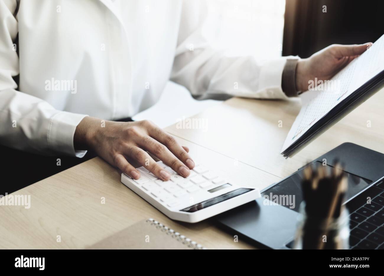 Business woman using calculator to review balance sheet annual using ...