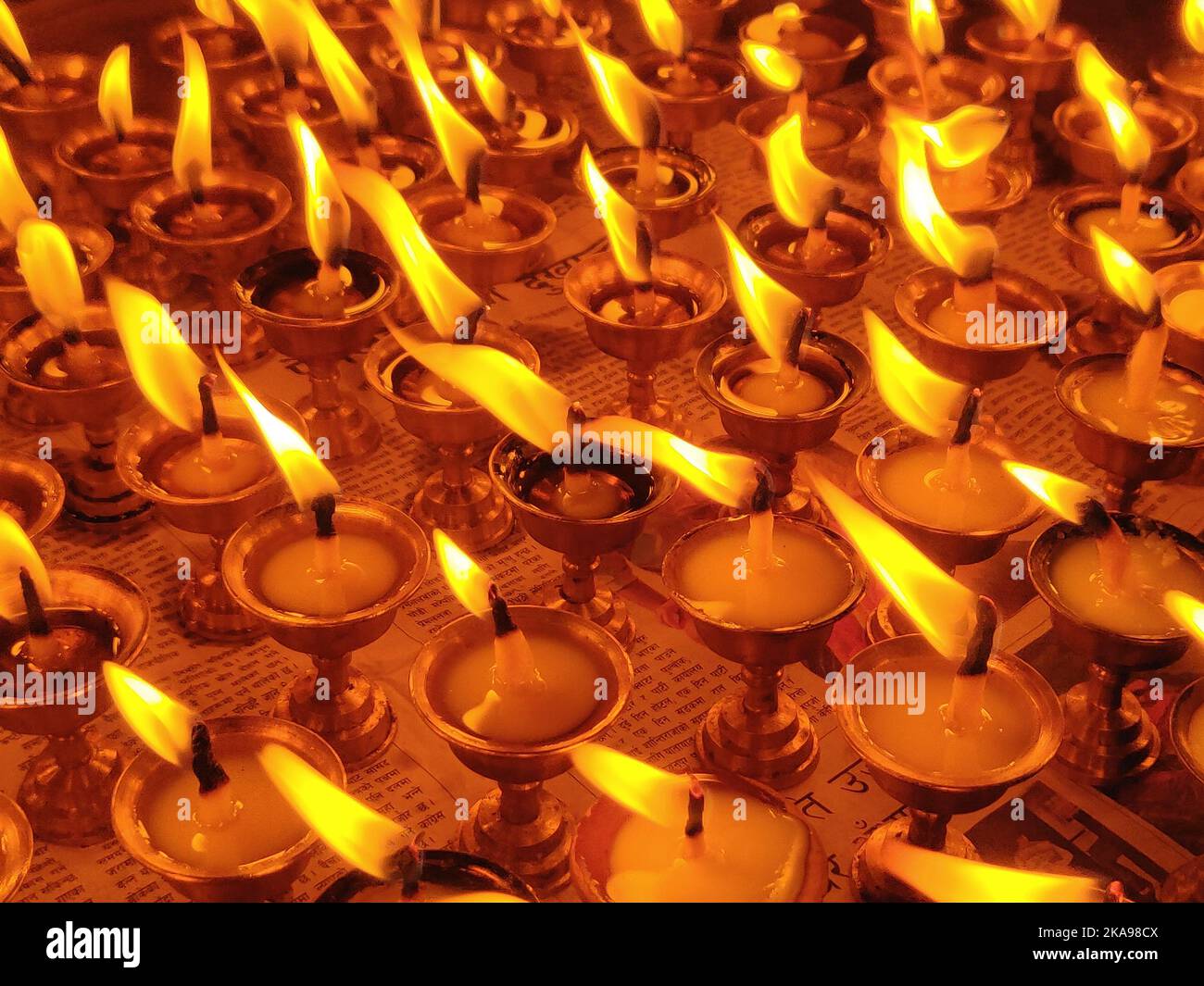 Many rows of candlesticks with burning candles Stock Photo - Alamy