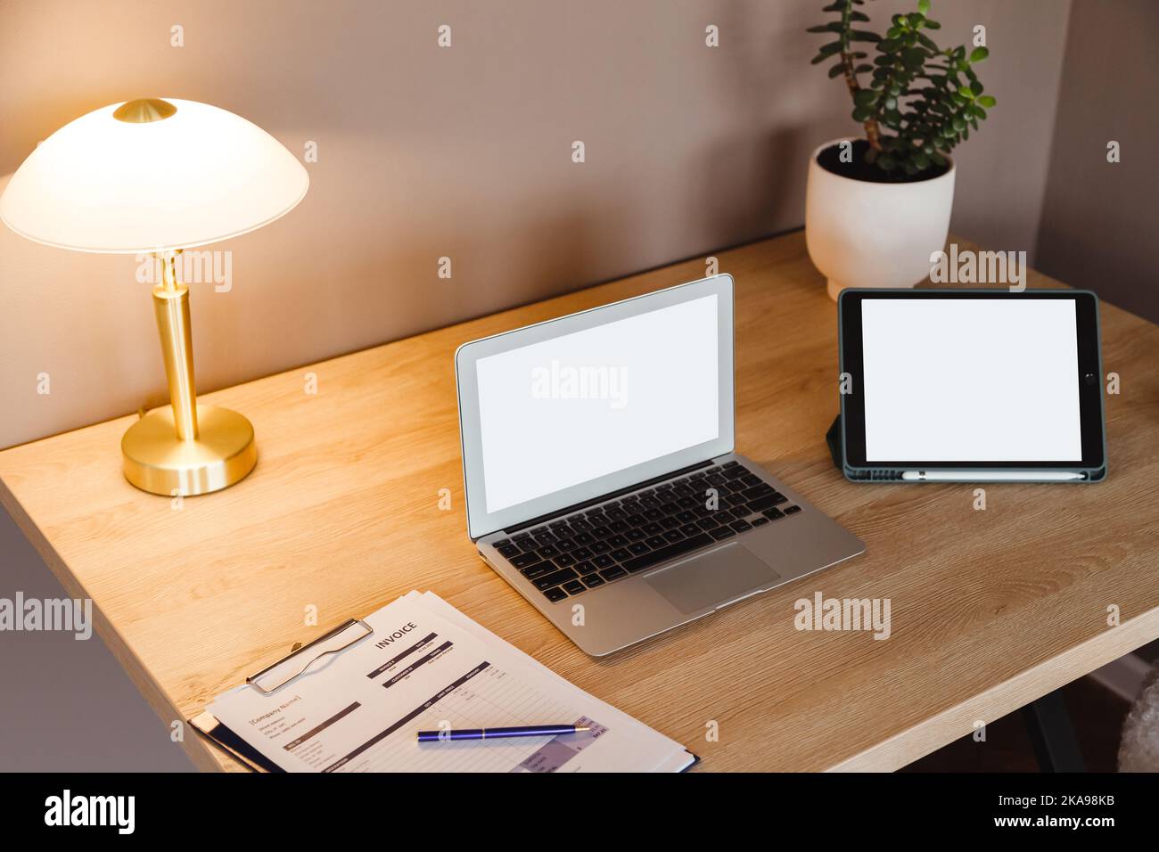 Modern workplace with laptop and tablet with white blank screen ...