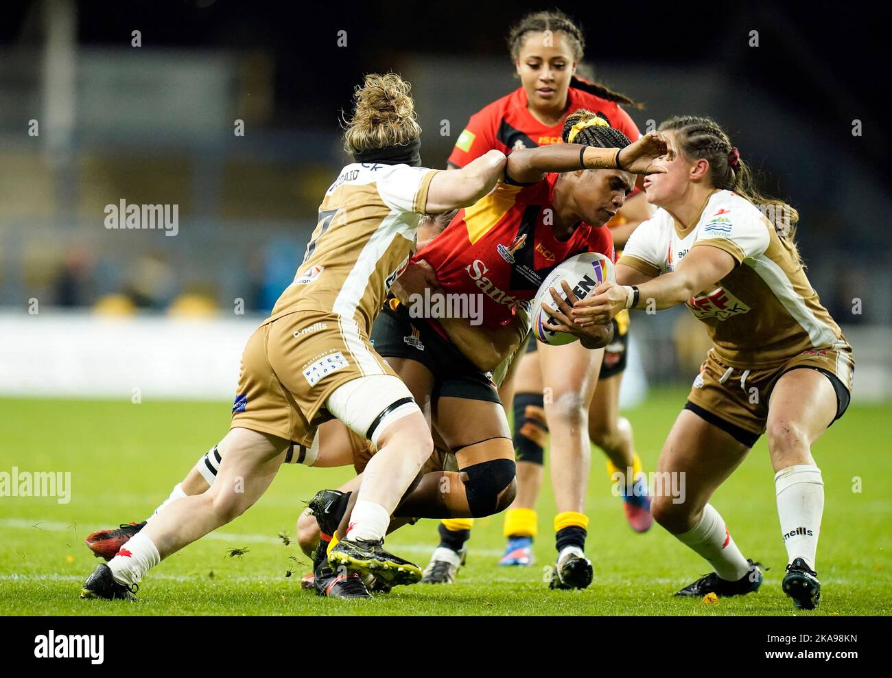 Papua New Guinea's Martha Molowia (centre) its tackled by Canada's ...
