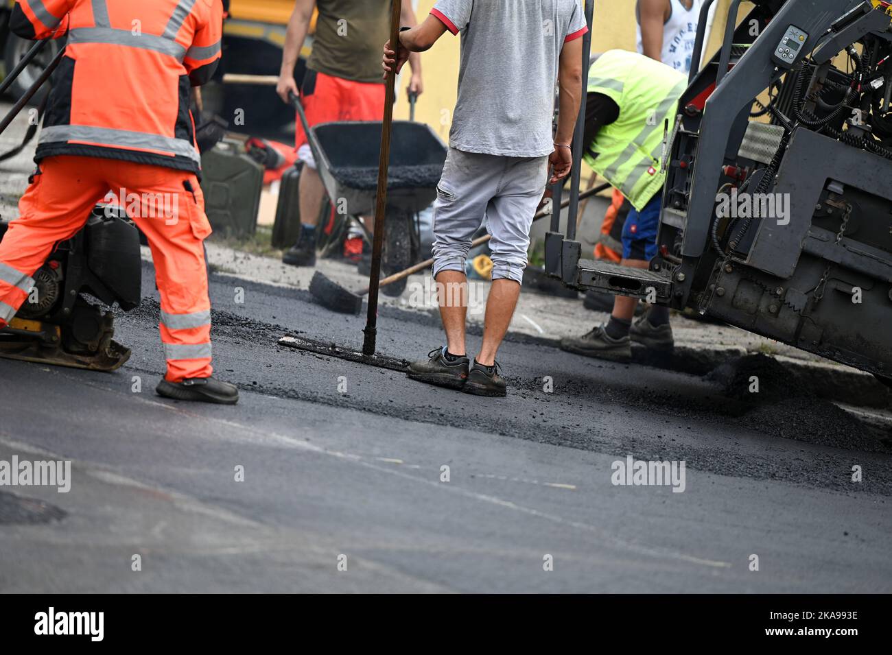 Feet of construction workers paving a road Stock Photo - Alamy
