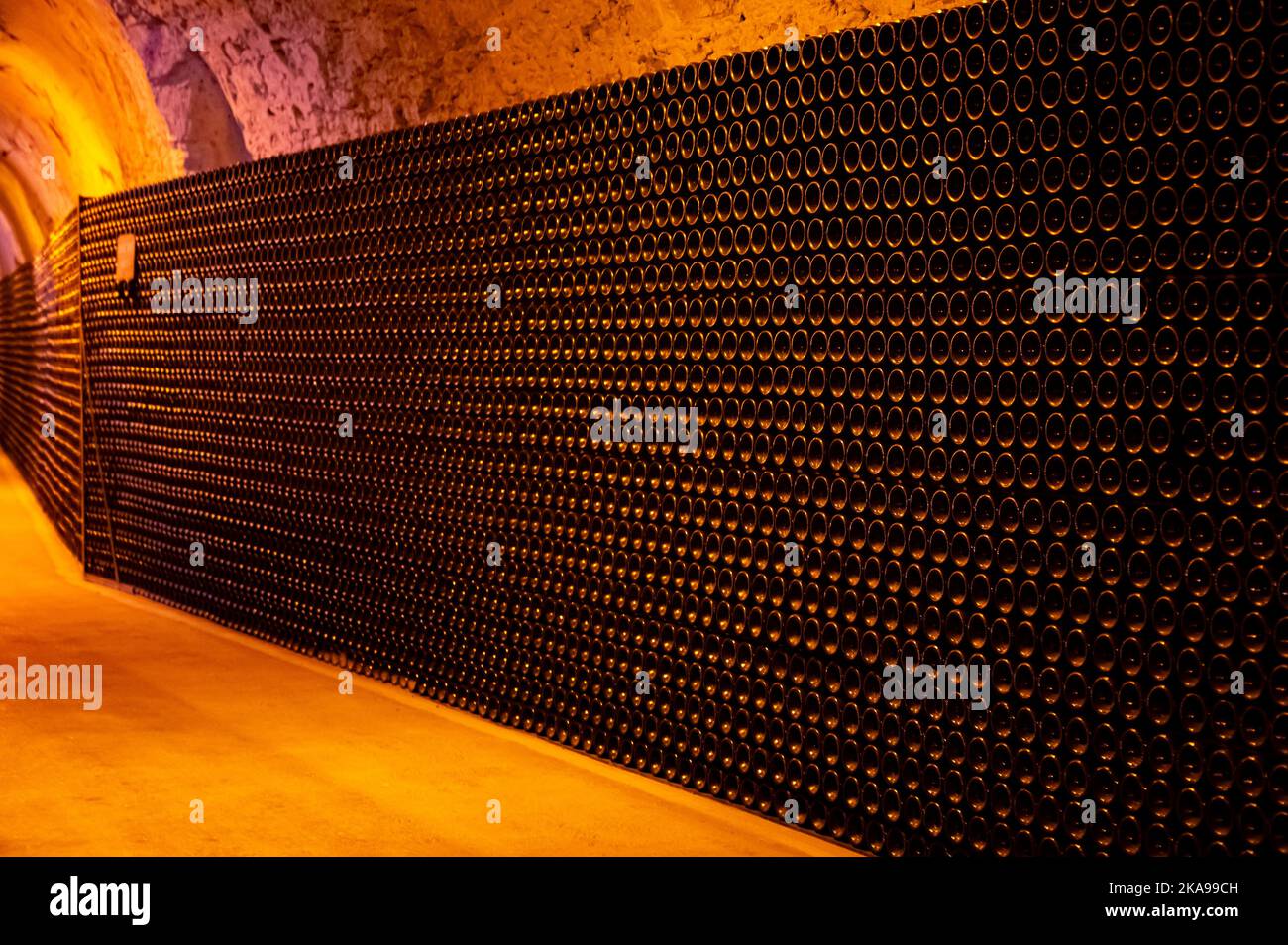 Walking in deep long undergrounds caves with dusty bottles on racks ...