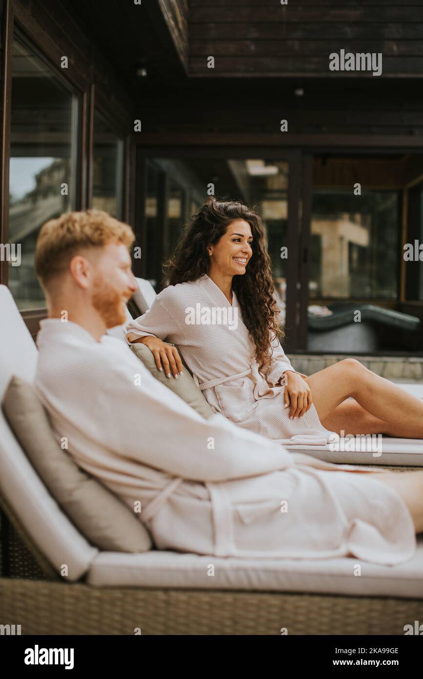 Handsome young couple relaxing on beds on the outdoor terrace Stock ...