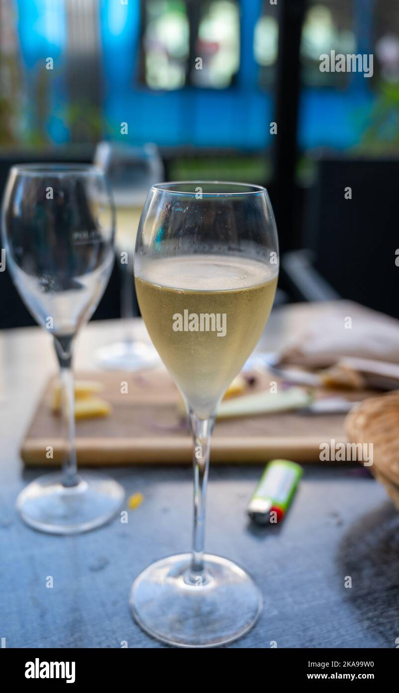 Tasting of white brut sparkling champagne wine outdoor in cafe in Reims ...