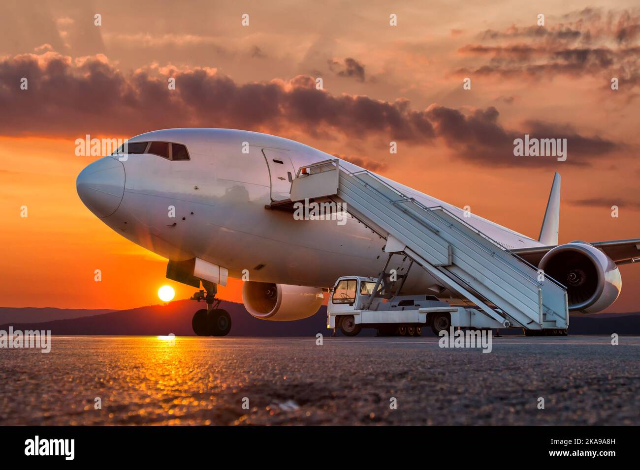 Wide body passenger airliner with air stairs at the airport apron ...