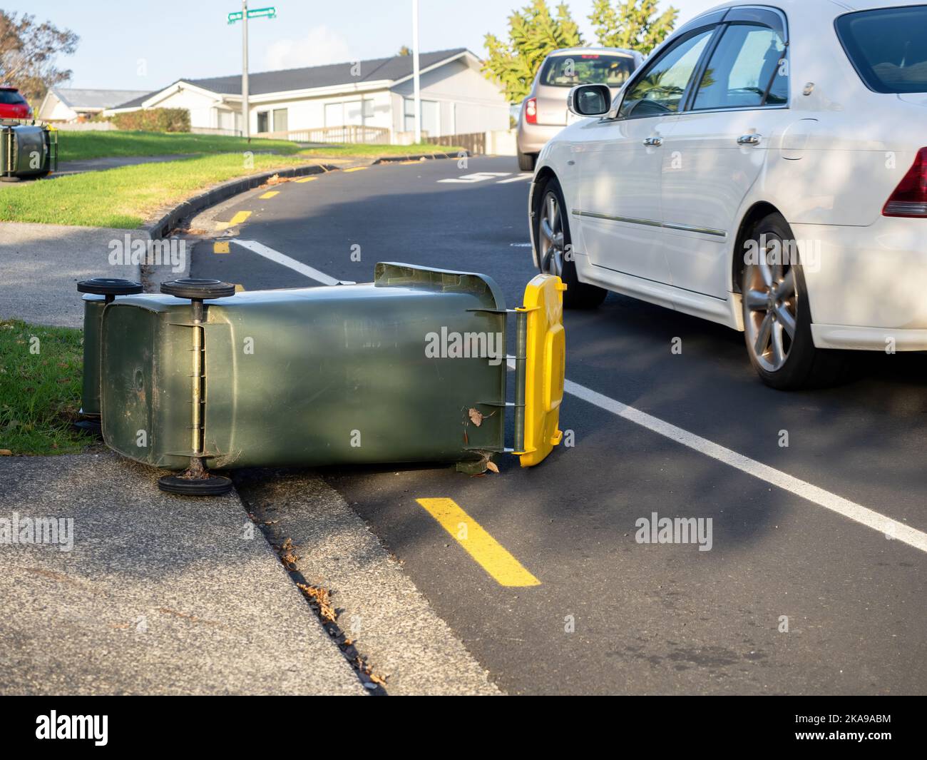 View of rubbish wheelie bins toppled by strong wind laying on ground ...