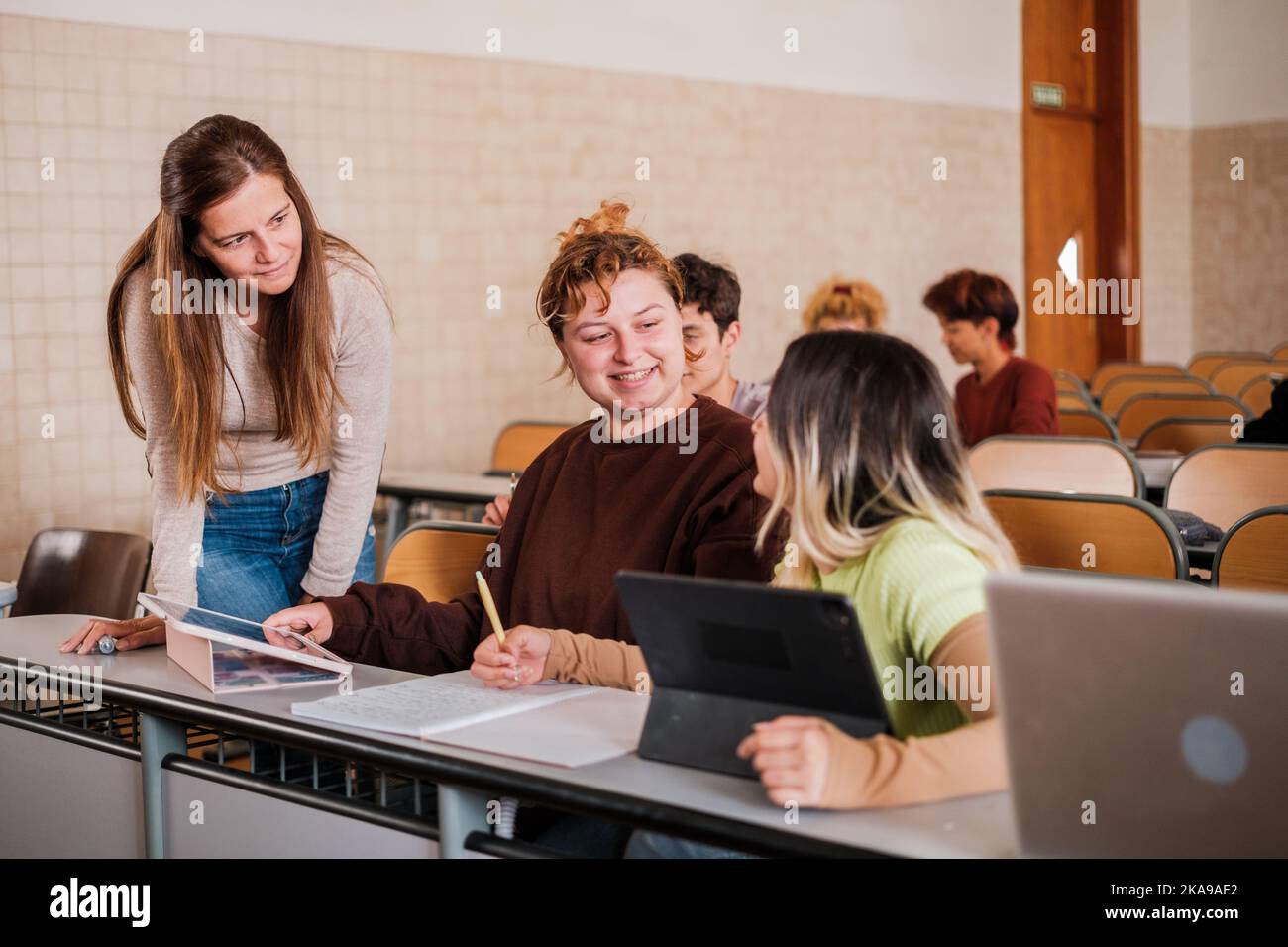 University professor explaining individually to her students in the ...