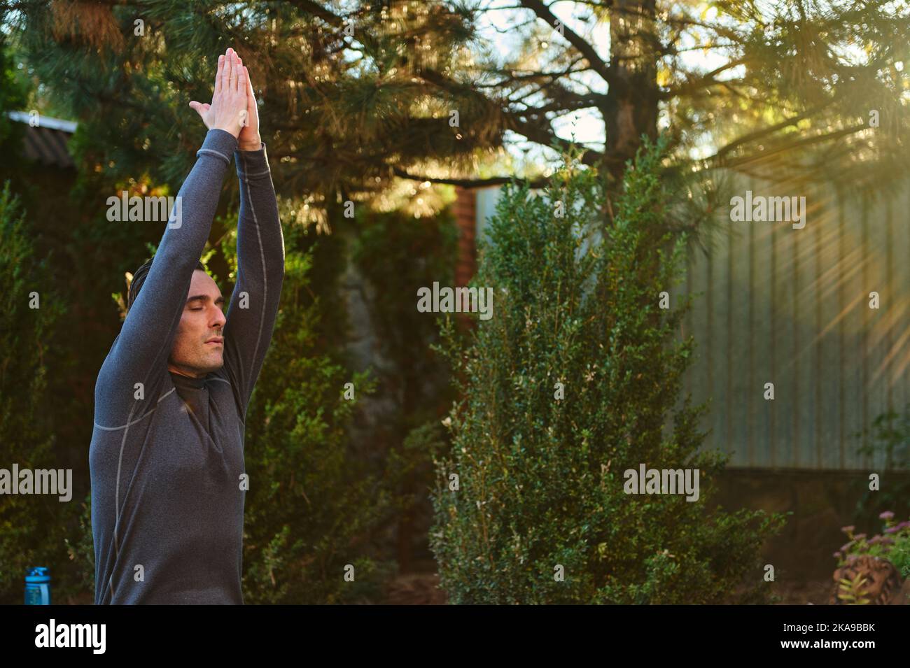 Active man athlete, yogi raising hands to the sky, palms to palm ...
