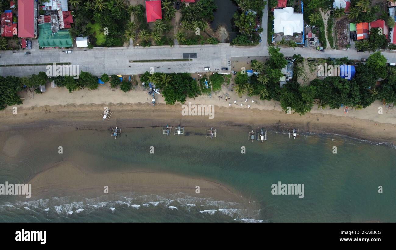An aerial drone shot overlooking Bayawan City Boulevard and the ocean ...