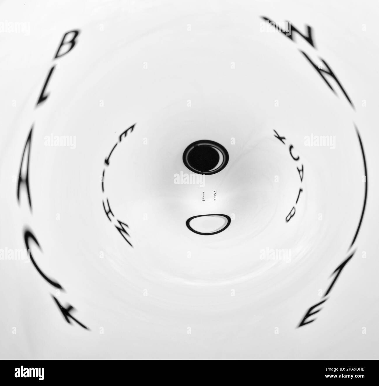 the words black and white reflected on a pool of spinning water Stock ...