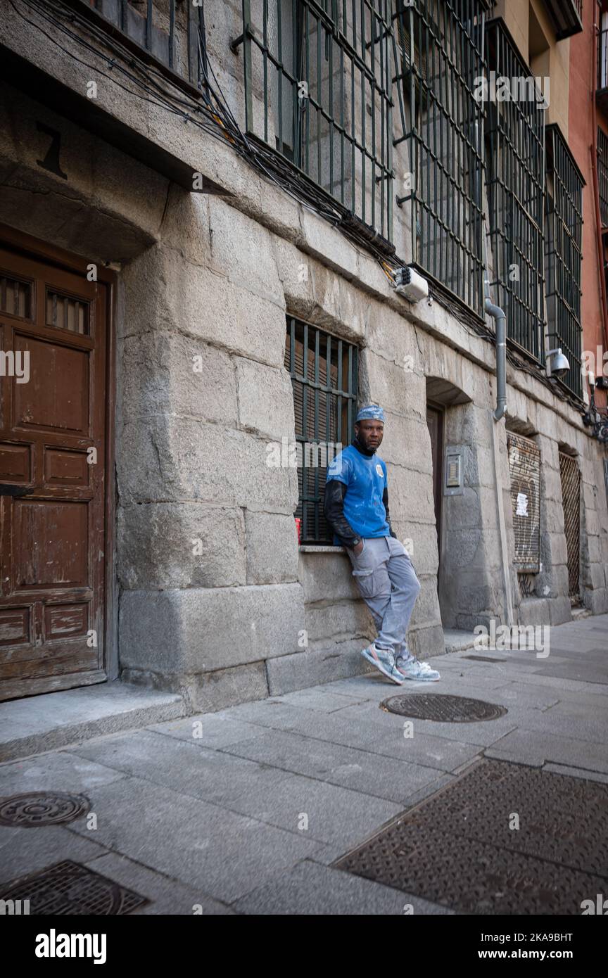 A vertical shot of a construction worker resting leaning on the facade ...