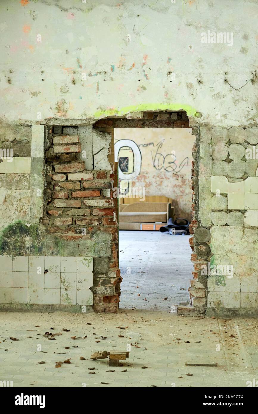 A damaged wall with opening in the abandoned psychiatric department ...