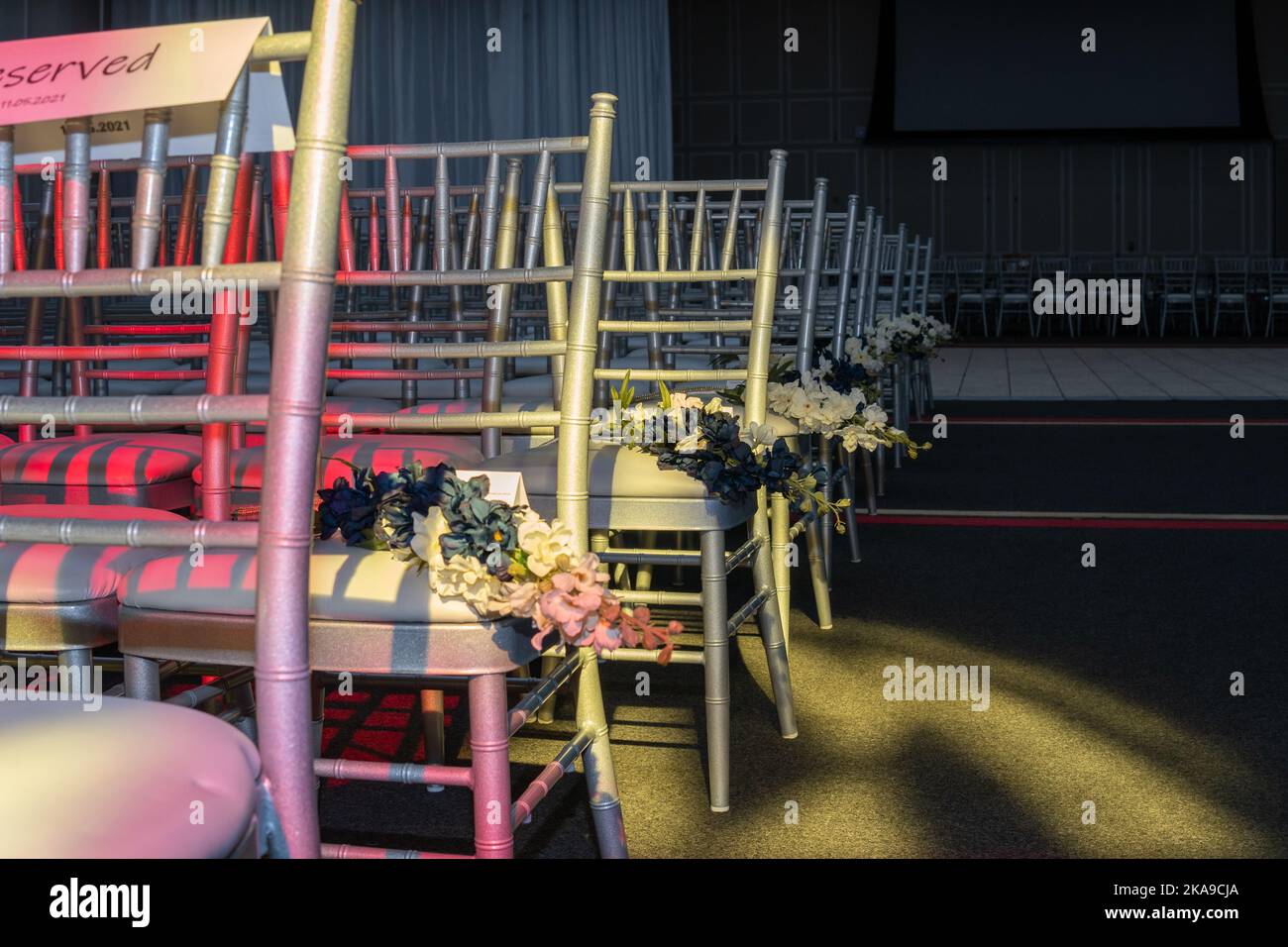 The rows of reserved seats with floral decorations at an event Stock ...